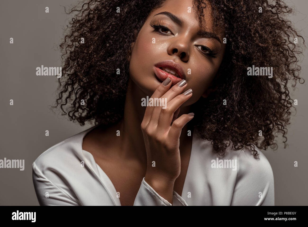 Young tender african american woman in white shirt with hand on lips ...