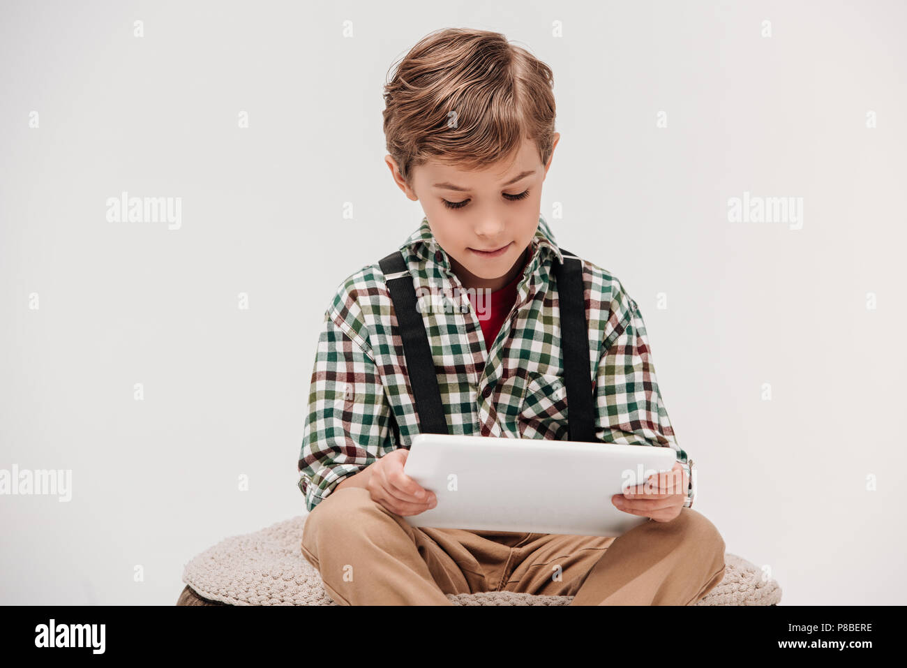 cute smiling little boy using digital tablet isolated on grey Stock ...