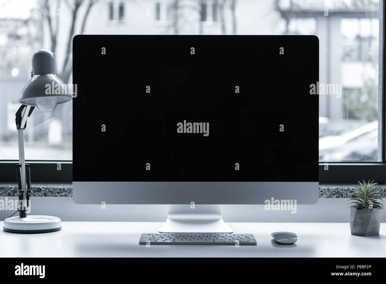 working table with computer in front of window Stock Photo - Alamy