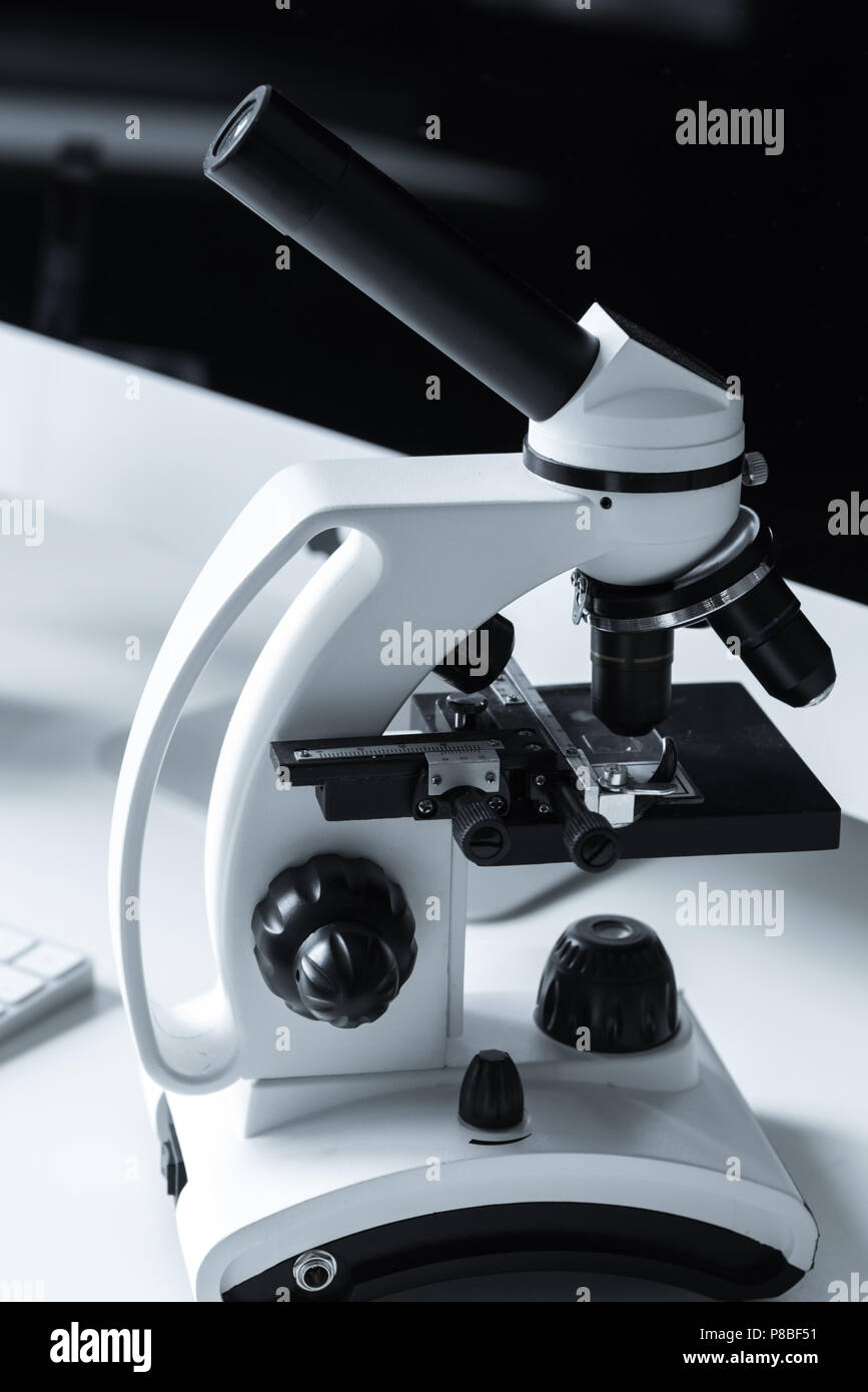 white and black microscope on working table Stock Photo - Alamy