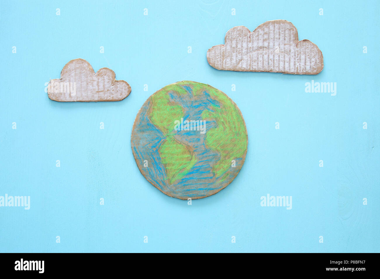 top view image of cardboard earth globe over blue wooden background ...