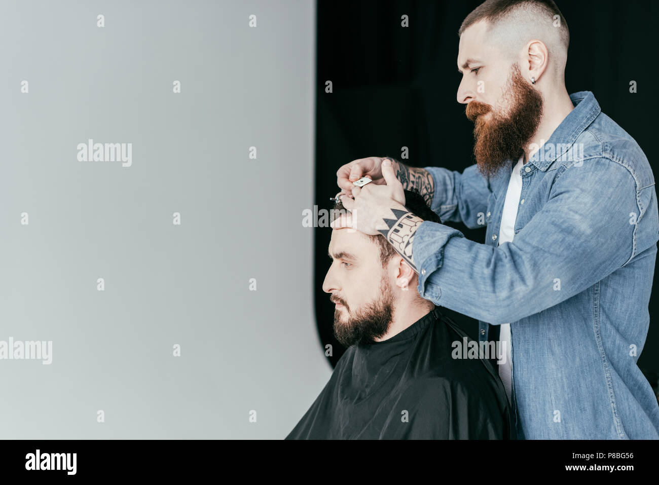 side view of barber cutting customer hair at barbershop Stock Photo - Alamy