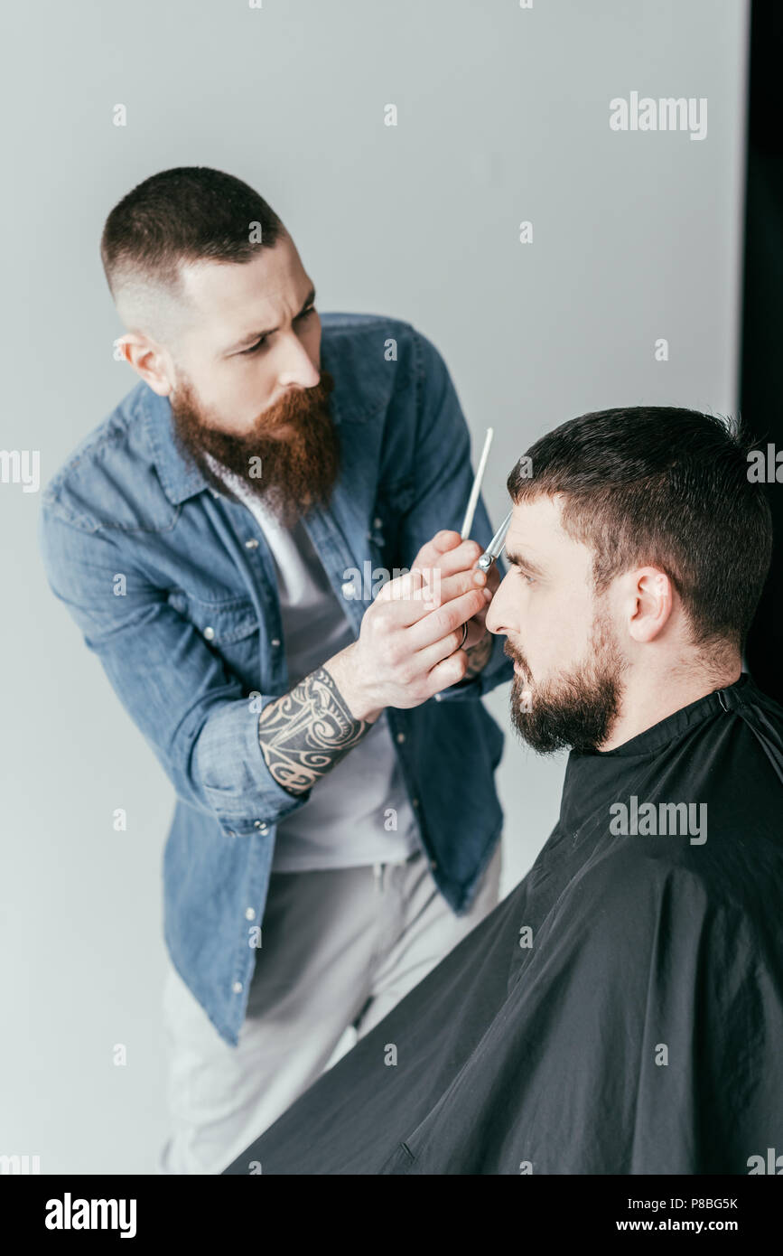 side view of barber cutting customer hair at barbershop isolated on ...