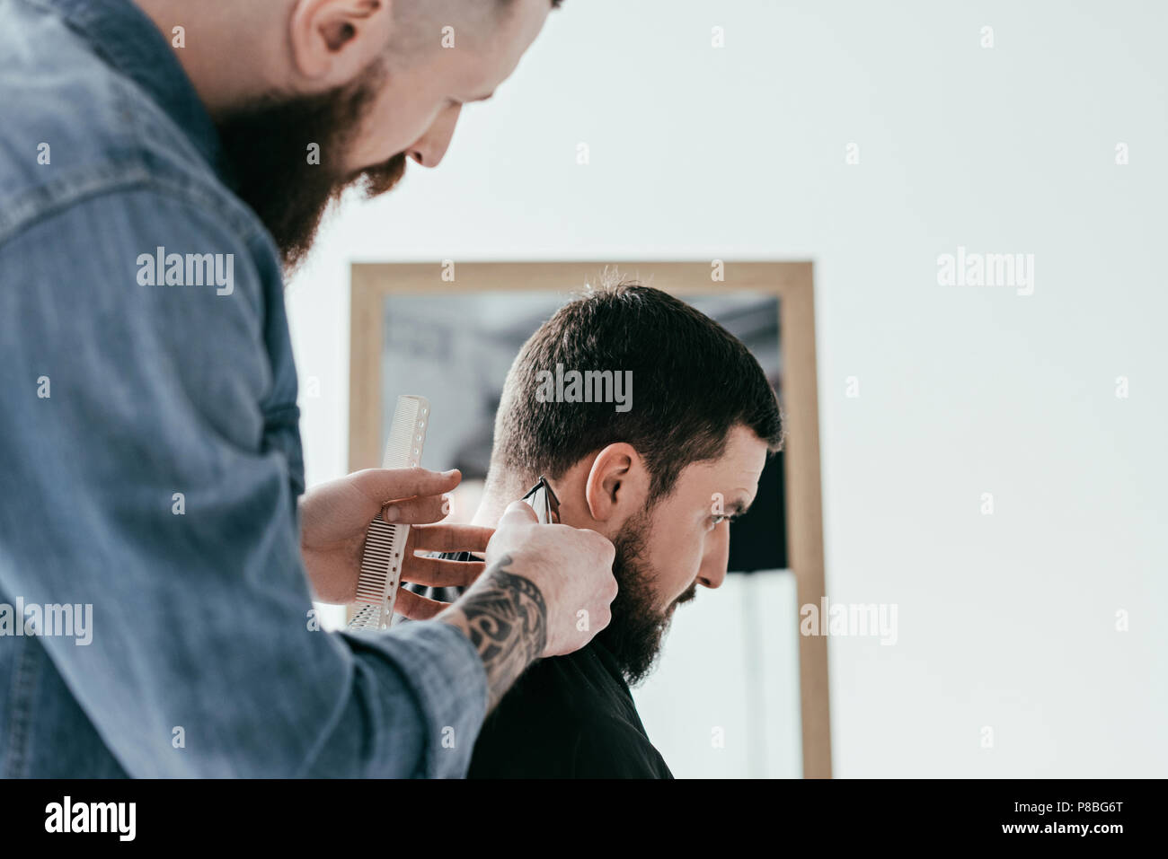 side view of barber shaving customer hair at barbershop isolated on ...