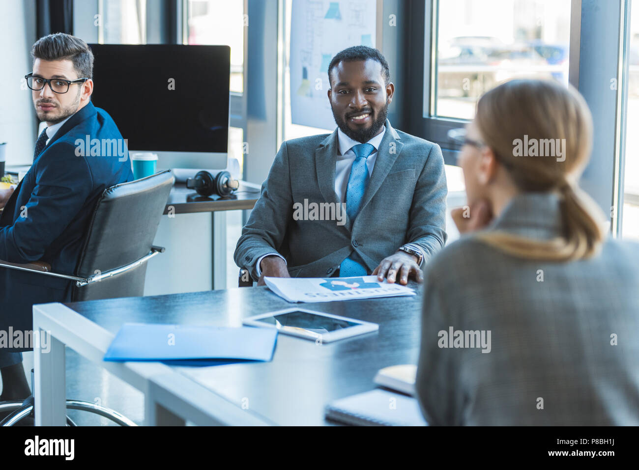 multicultural businesspeople talking at table in office Stock Photo - Alamy