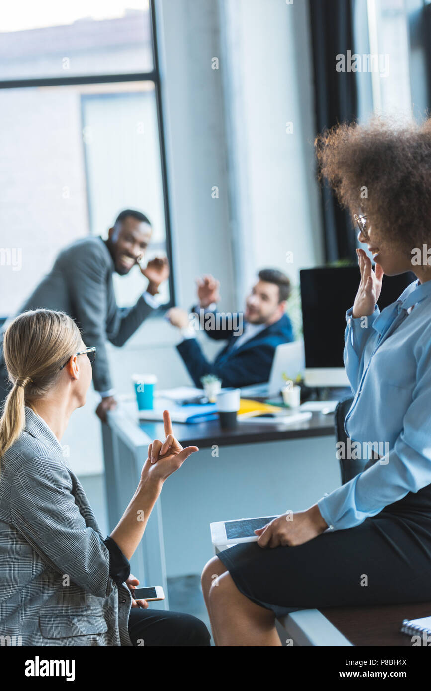 businesswoman showing middle finger to colleagues in office Stock Photo ...