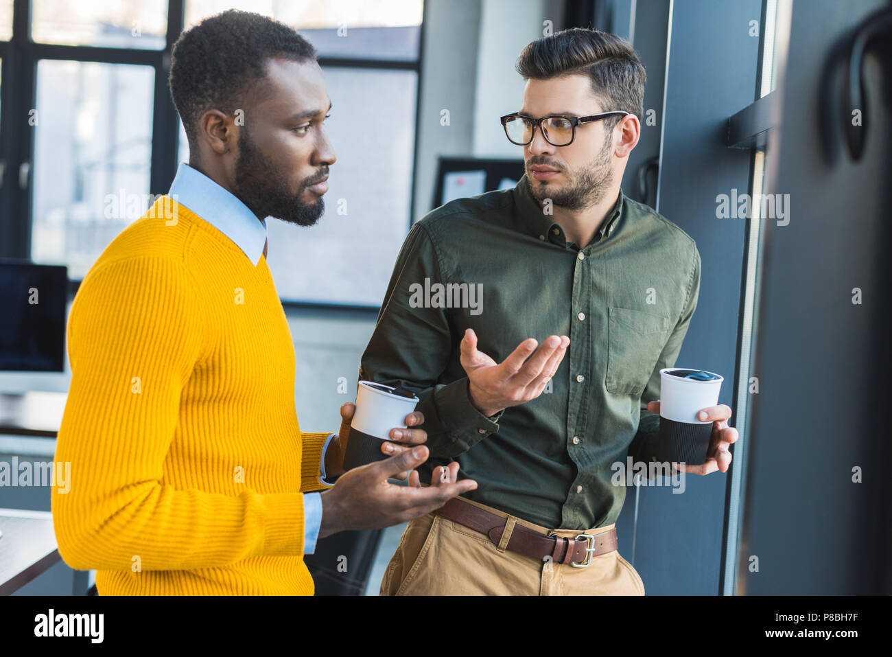 multicultural businessmen talking during coffee break in office Stock ...