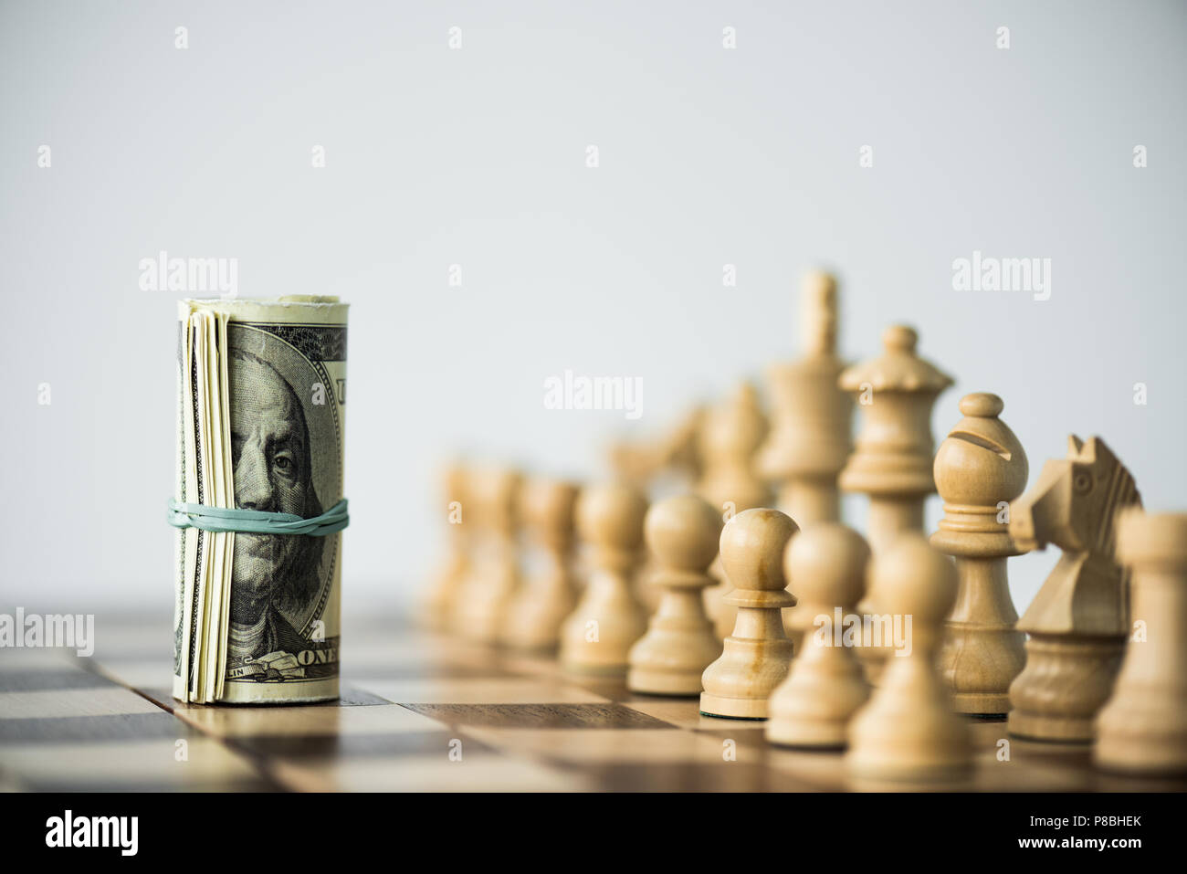 Chess pieces and rolled up cash on chess board isolated on white Stock ...