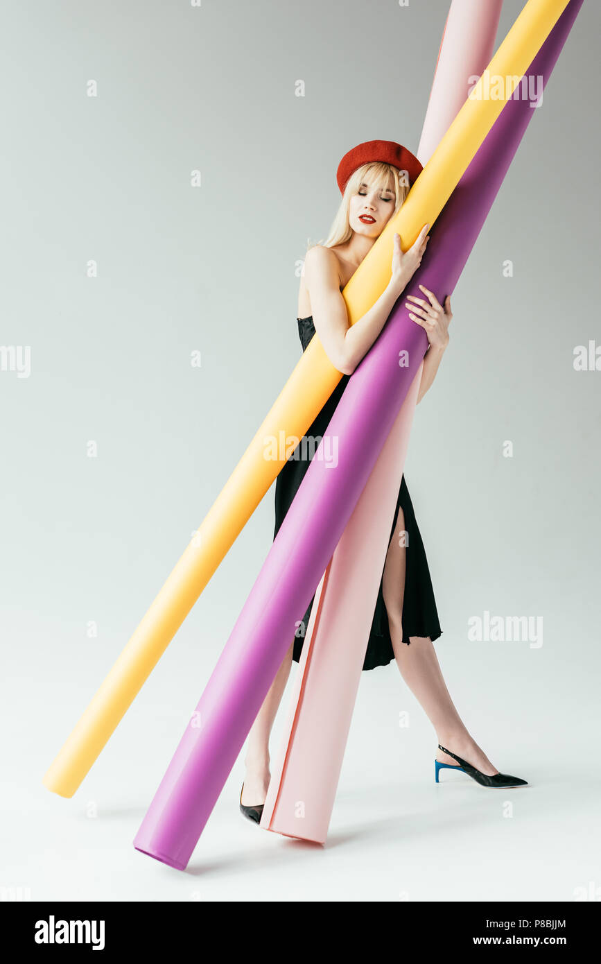 Elegant blonde girl holding colorful paper rolls Stock Photo - Alamy
