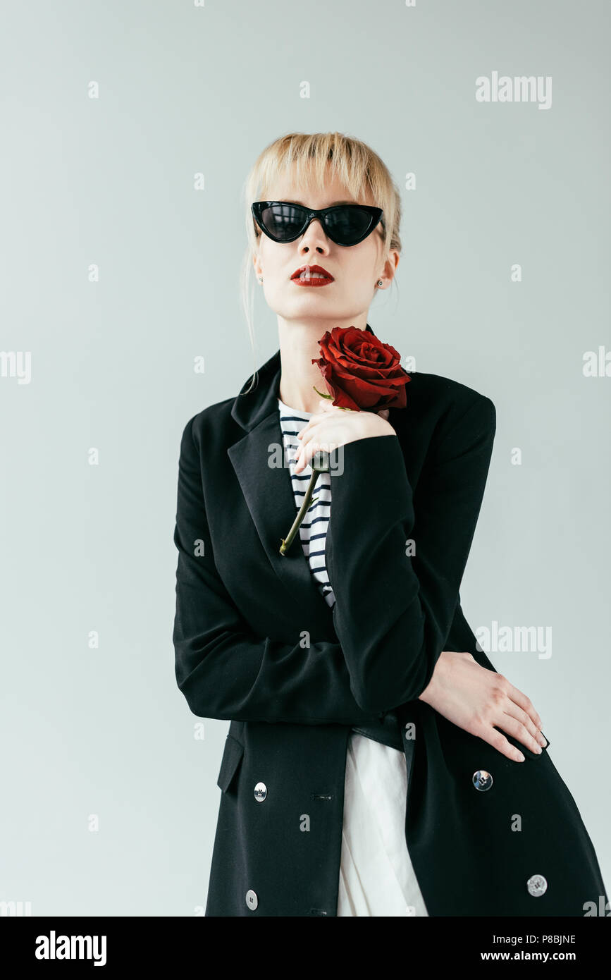 Smiling blonde girl holding red rose isolated on grey Stock Photo - Alamy