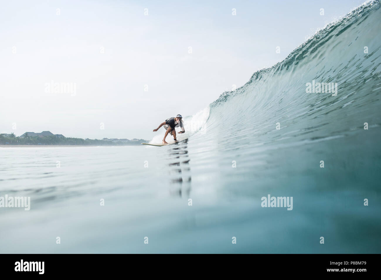 young sportive man riding surfboard in ocean Stock Photo - Alamy