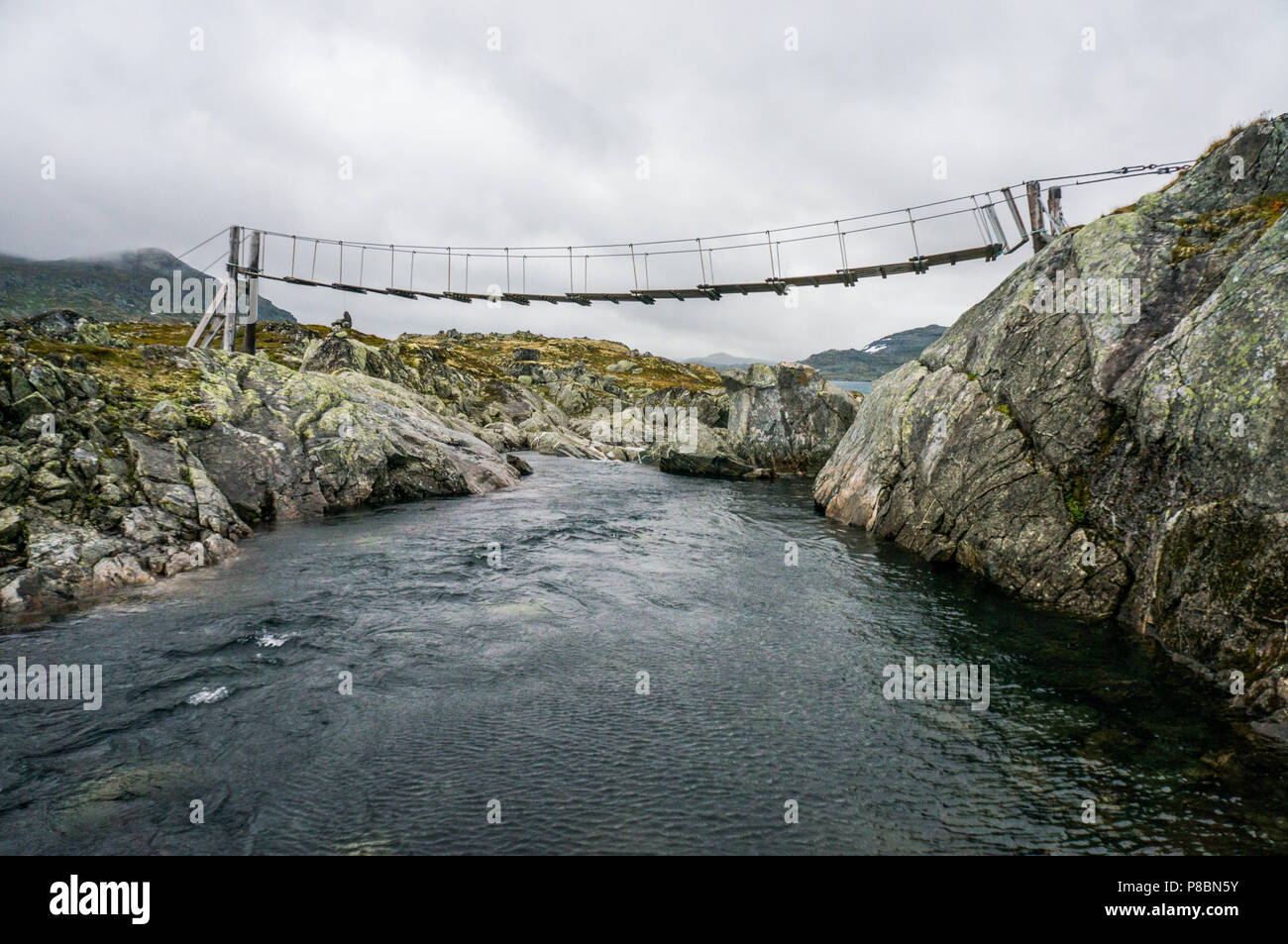 landscape with hinged bridge over mountain river Stock Photo - Alamy