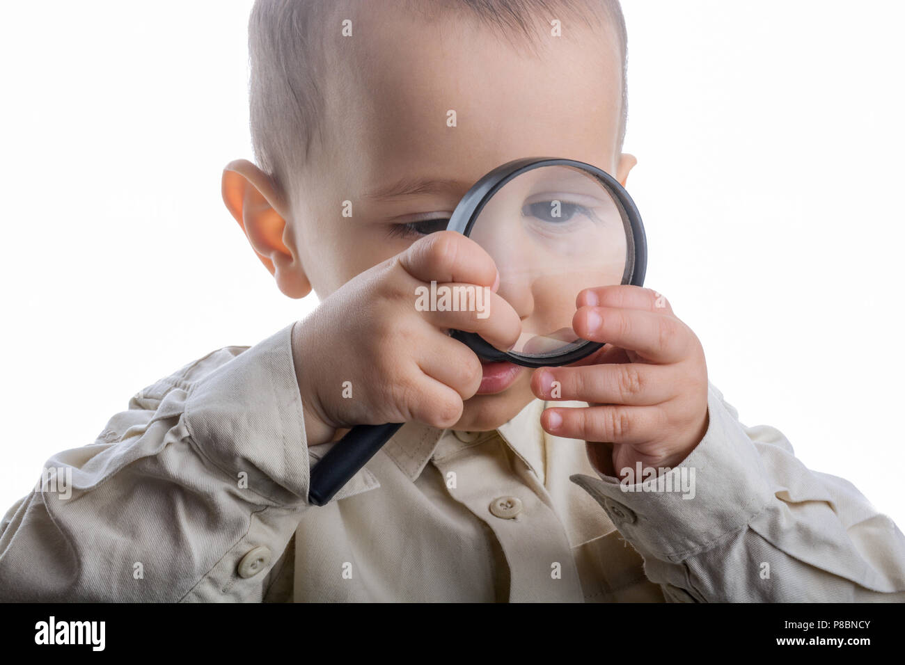 Baby holding a magnifying glass in hand on a white background Stock ...