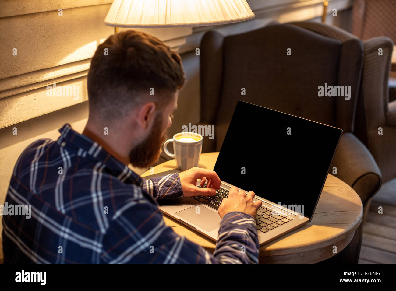 Young man chatting via net-book during work break in coffee shop, male ...
