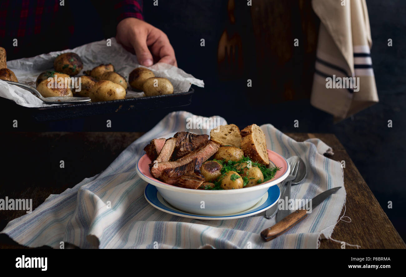 Plate with fresh fried potatoes and meat on a wooden table. Rustic ...