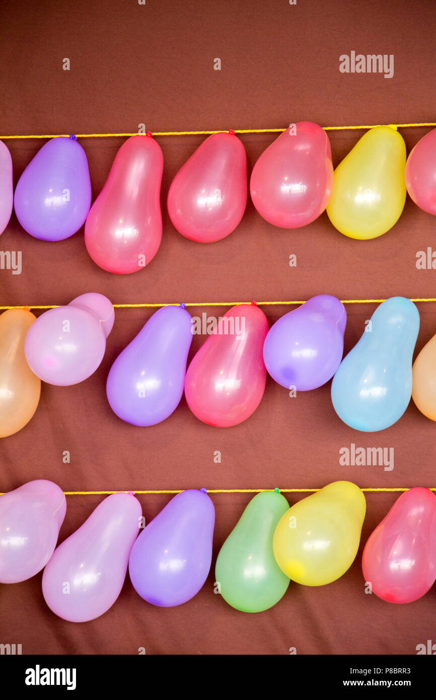 Balloon shooting game with balloons tied on a string Stock Photo - Alamy