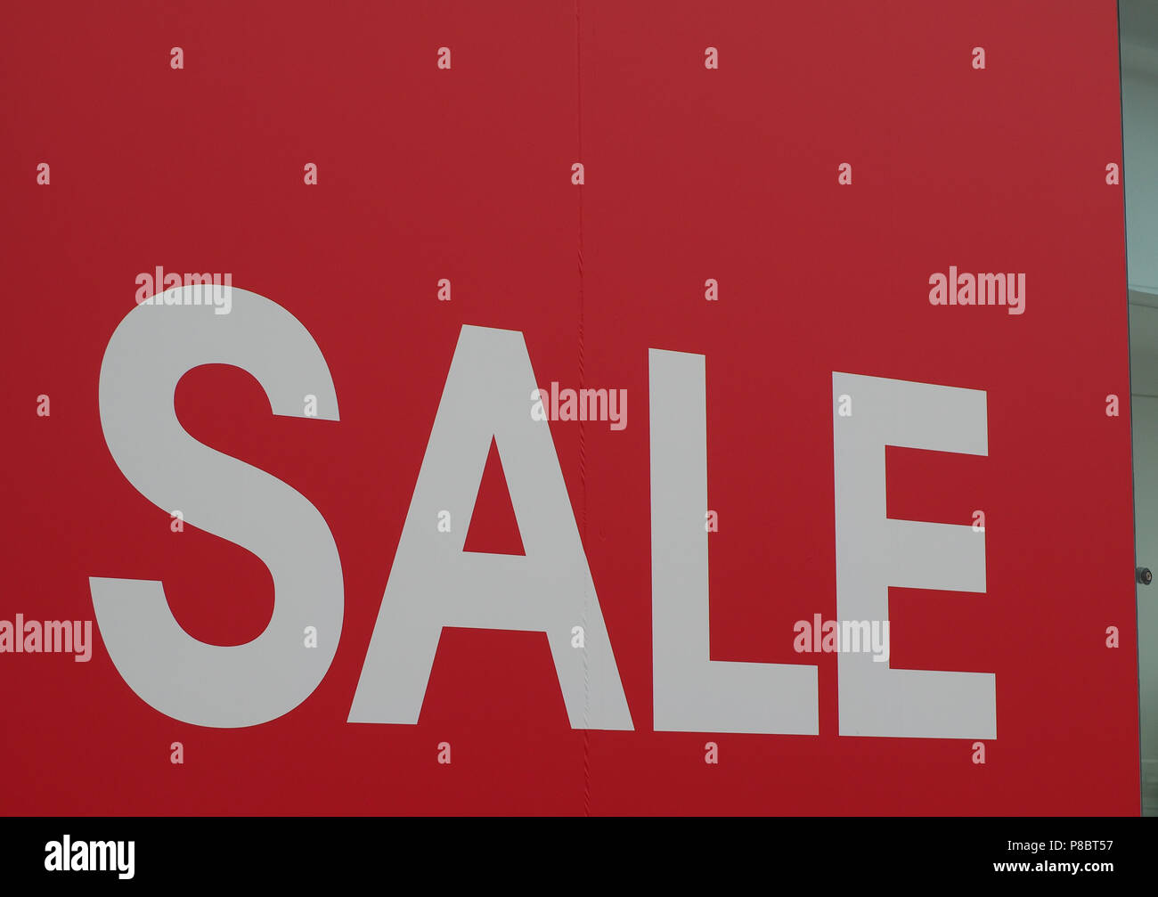 sale sign in a shop window, white over red Stock Photo - Alamy