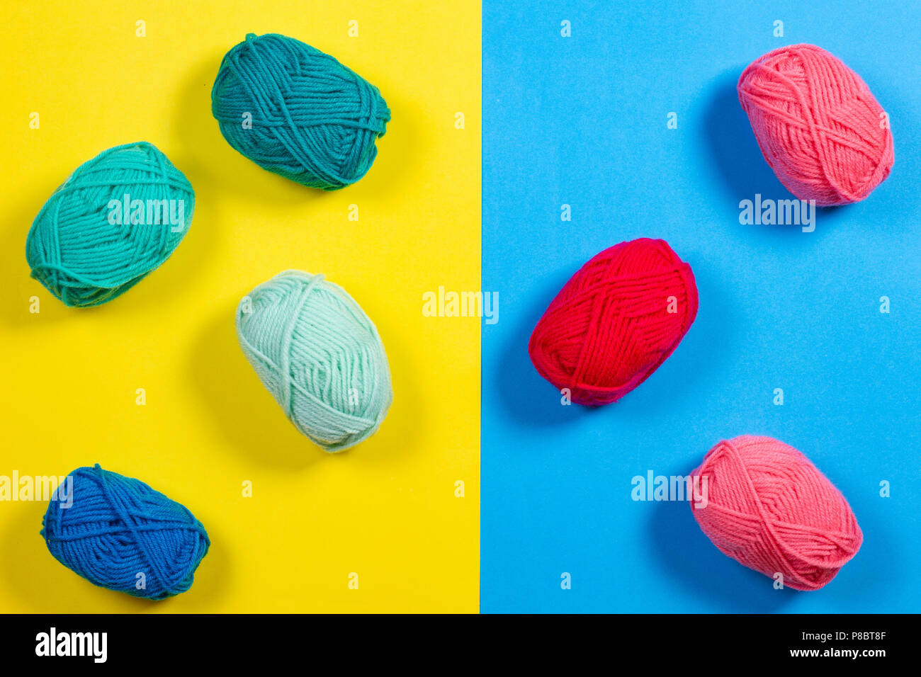 Colorful yarn for knitting on yellow and blue background Stock Photo ...