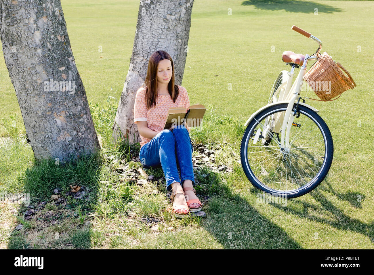 Woman sitting under tree writing hi-res stock photography and images ...