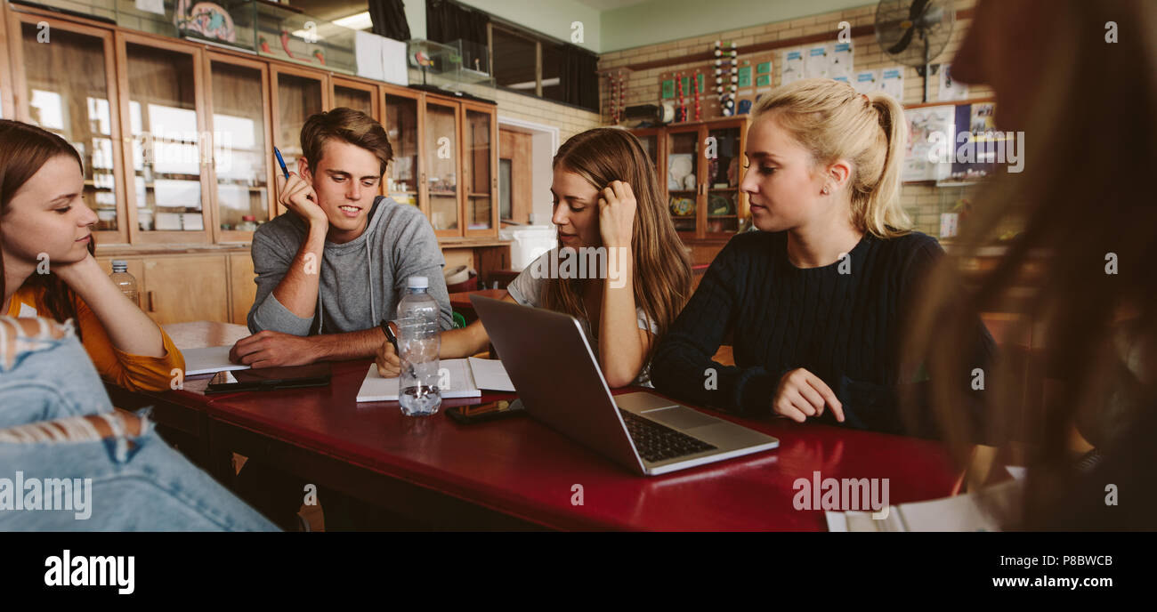 High school classmates sitting around a table and talking . Group study ...