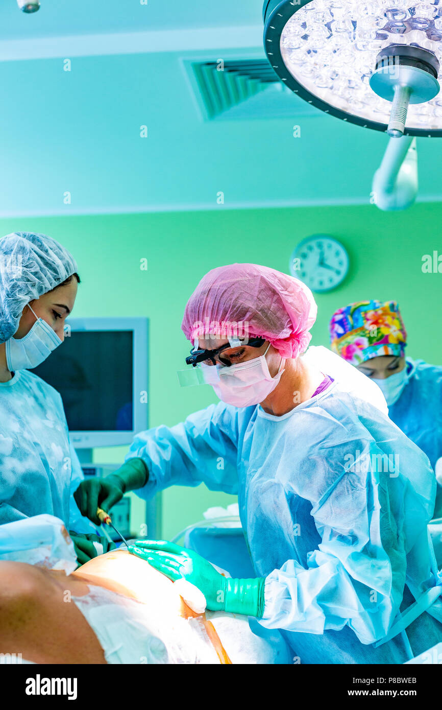 cosmetic liposuction surgery in actual operating room setting showing ...