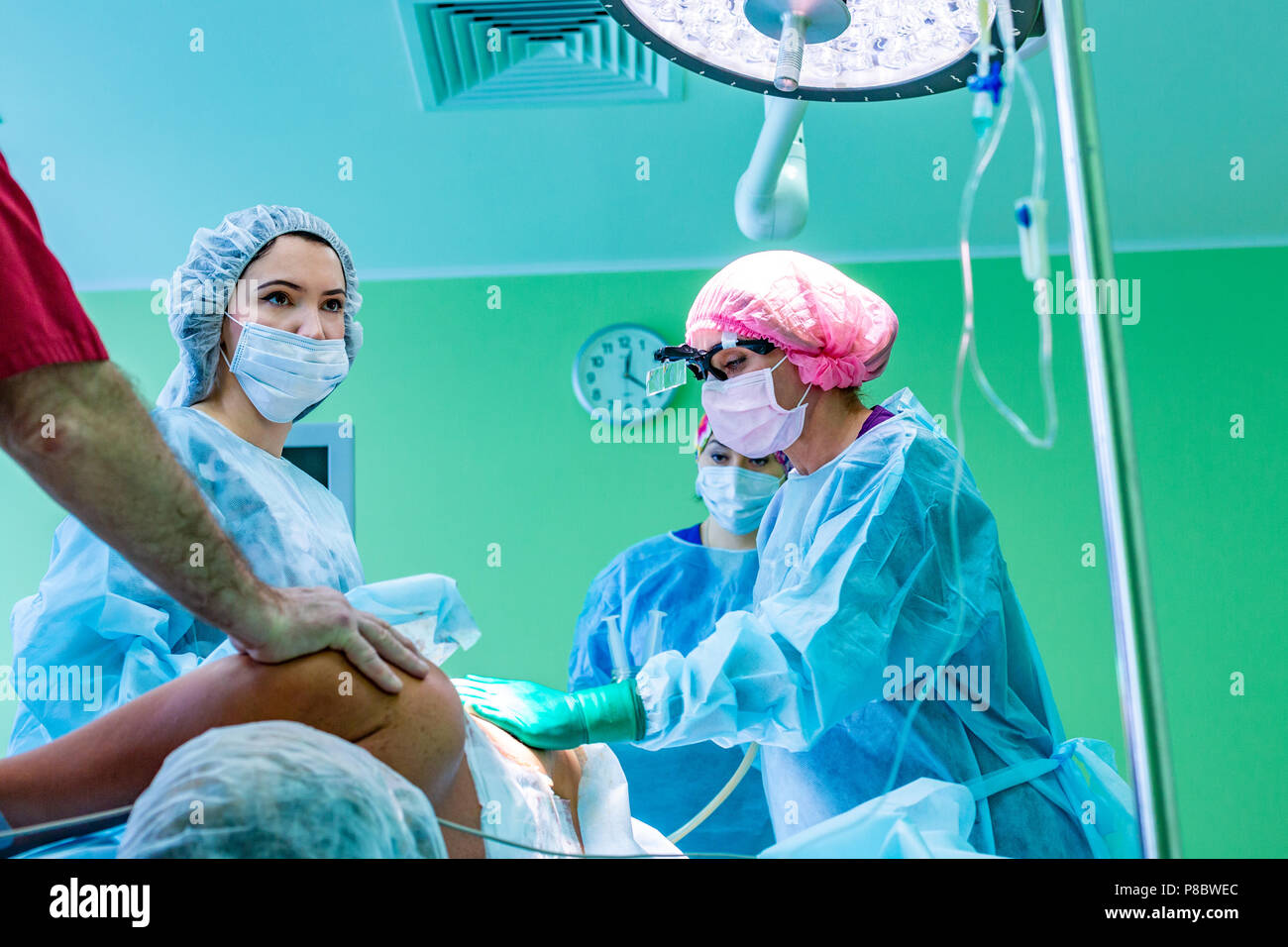 cosmetic liposuction surgery in actual operating room setting showing ...