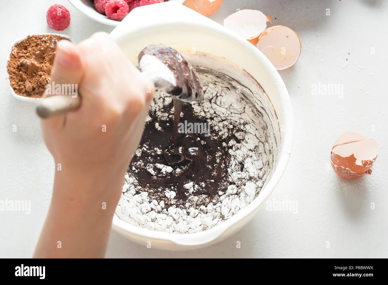 Preparing chocolate brownies, mixing batter with wooden spoon Stock ...