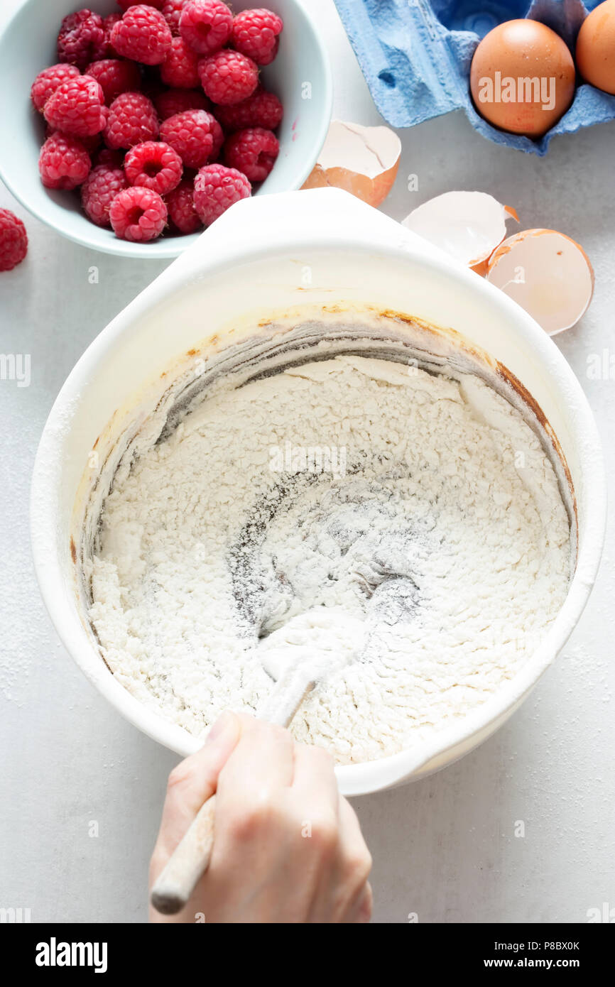 Mixing flour into chocolate brownies batter with wooden spoon, female ...