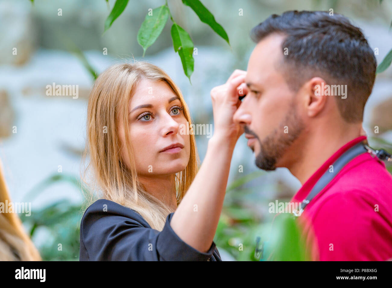 Makeup artist applying makeup on model before shooting series Stock ...