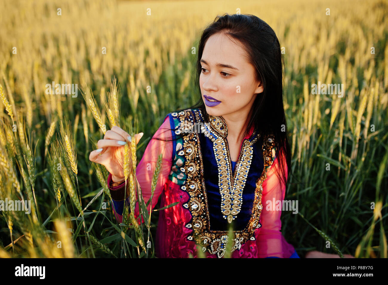 Tender indian girl in saree, with violet lips make up posed at field in ...
