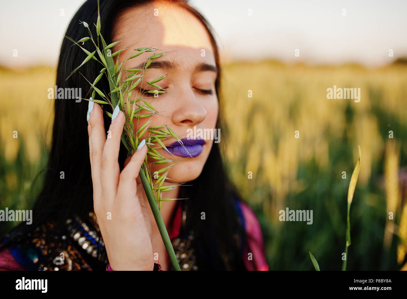 Tender indian girl in saree, with violet lips make up posed at field in ...