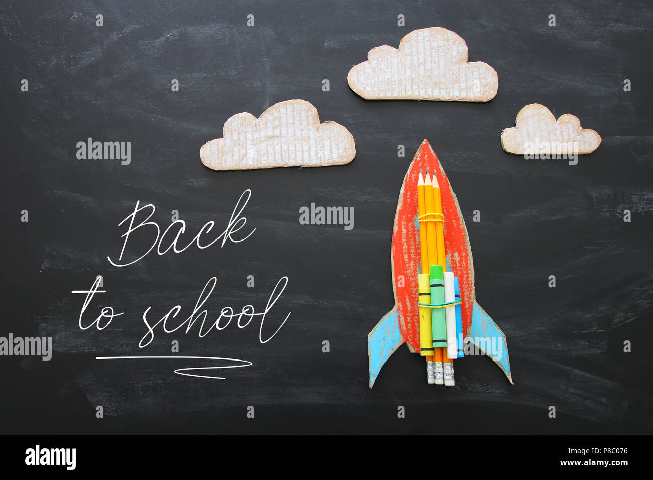 Back to school concept. Top view image of handmade cardboard rocket and ...