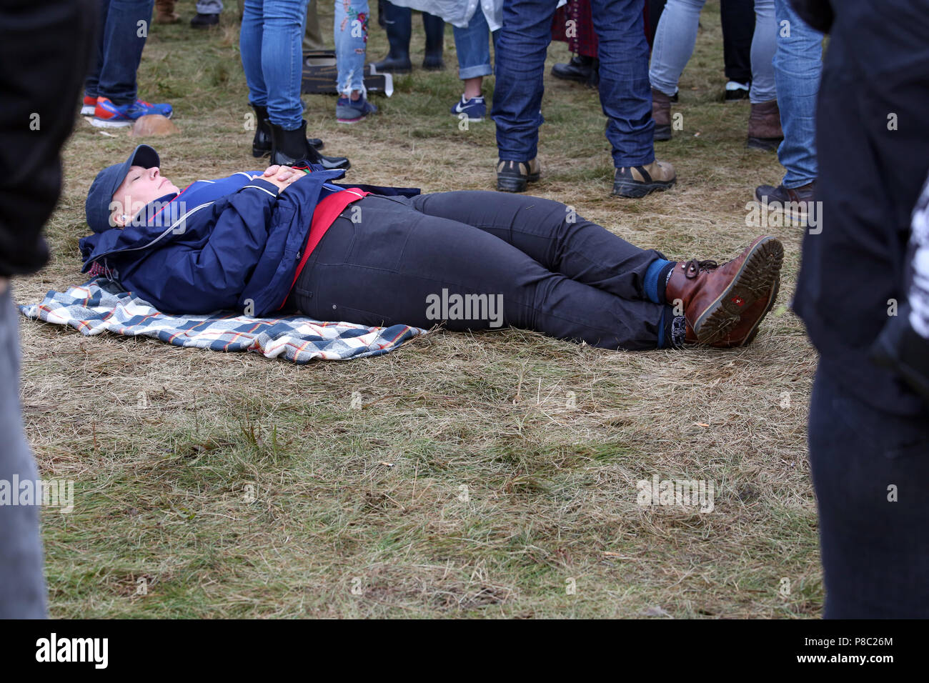 Hoppegarten, Germany, woman is sleeping in the midst of a crowd on the ...