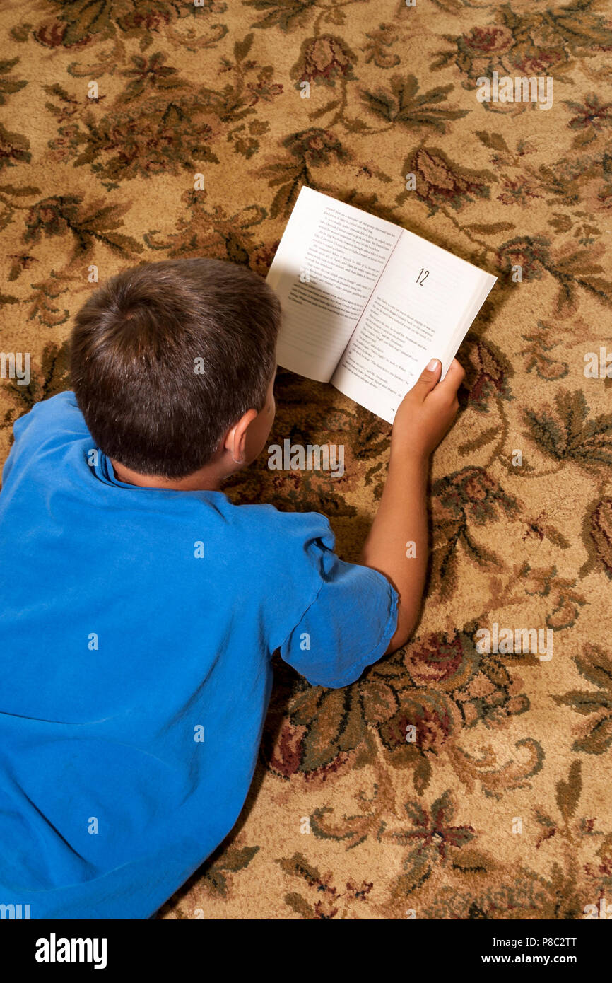 Boy reading book on carpet. MR. © Myrleen Pearson Stock Photo - Alamy