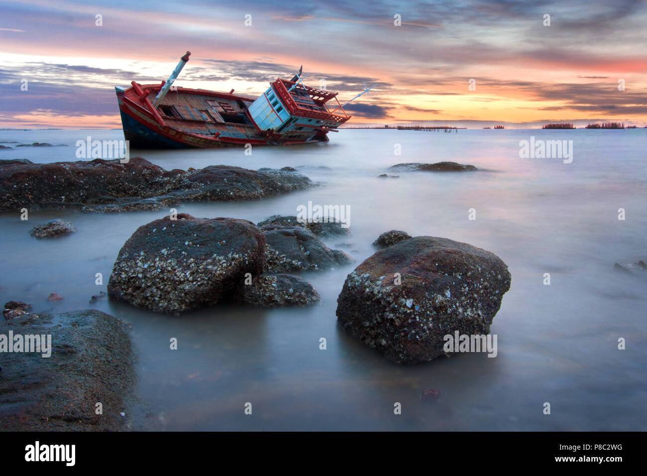 shipwreck stranded on the beach at sunset Stock Photo - Alamy