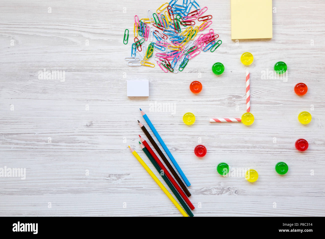 Back to school. Clock made of colorful sweet candies. Nine o'clock on ...