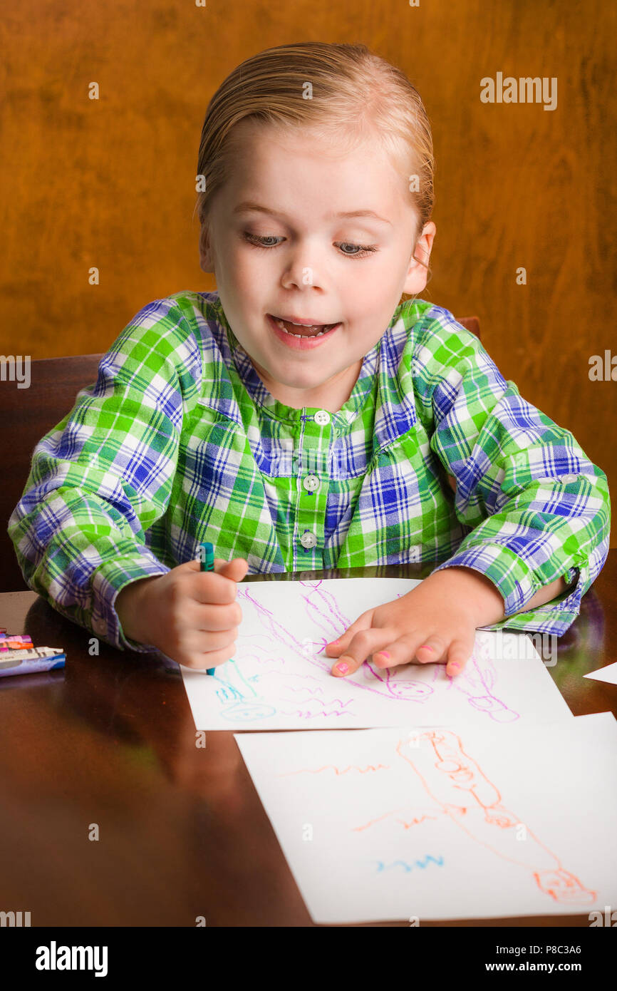 Very happy expression on a child while she is drawing a picture for her ...
