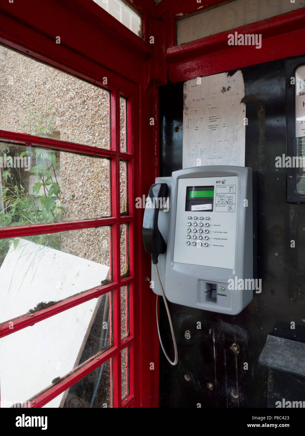 A faded red telephone box stands next to a ruined cottage at Bridgend ...