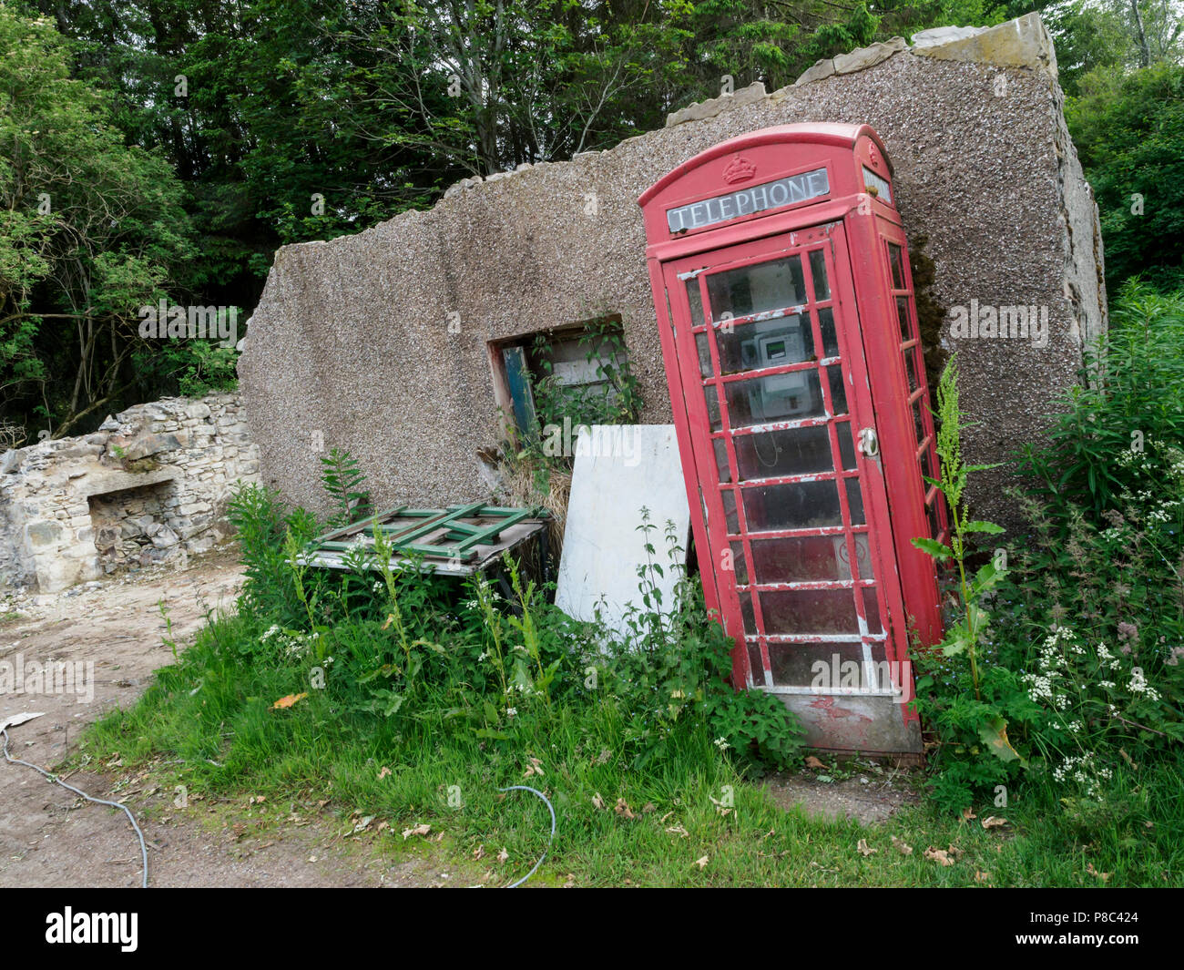 A faded red telephone box stands next to a ruined cottage at Bridgend ...