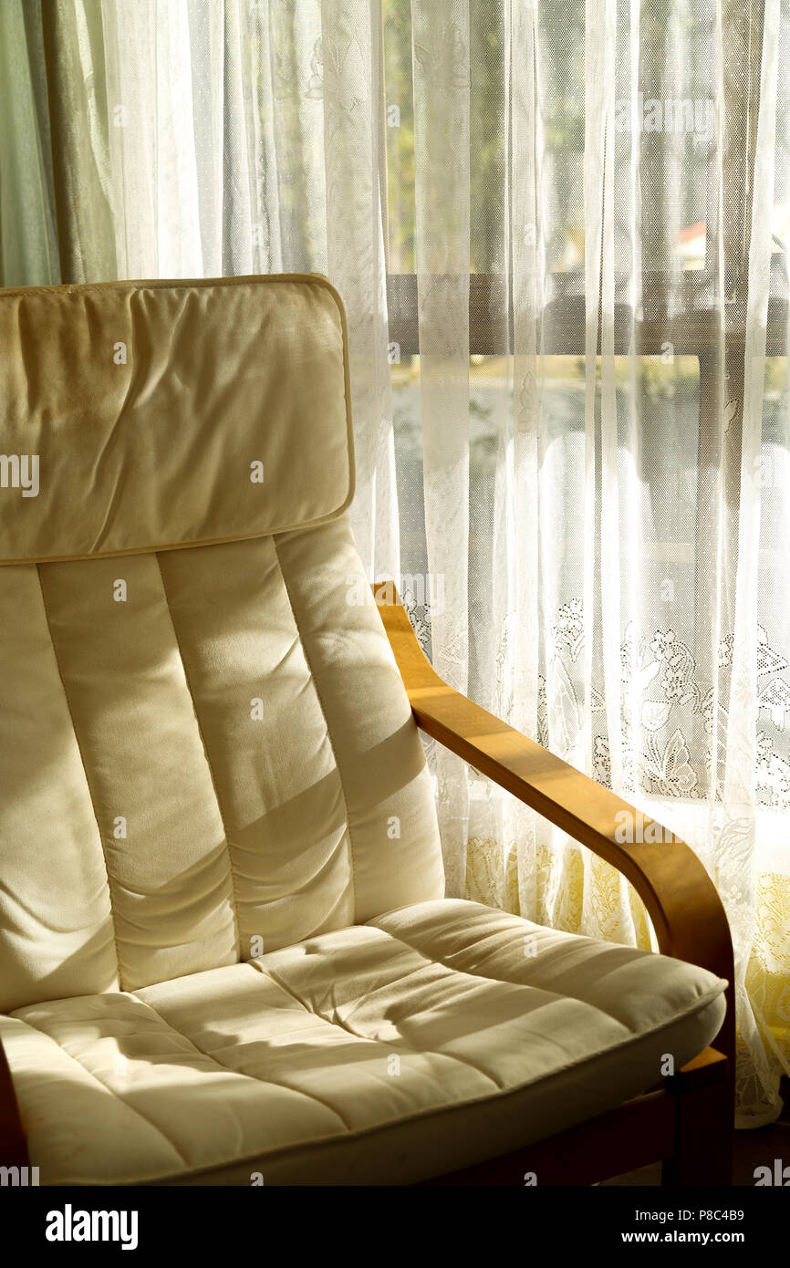 Chair by a sunny window with curtains Stock Photo - Alamy