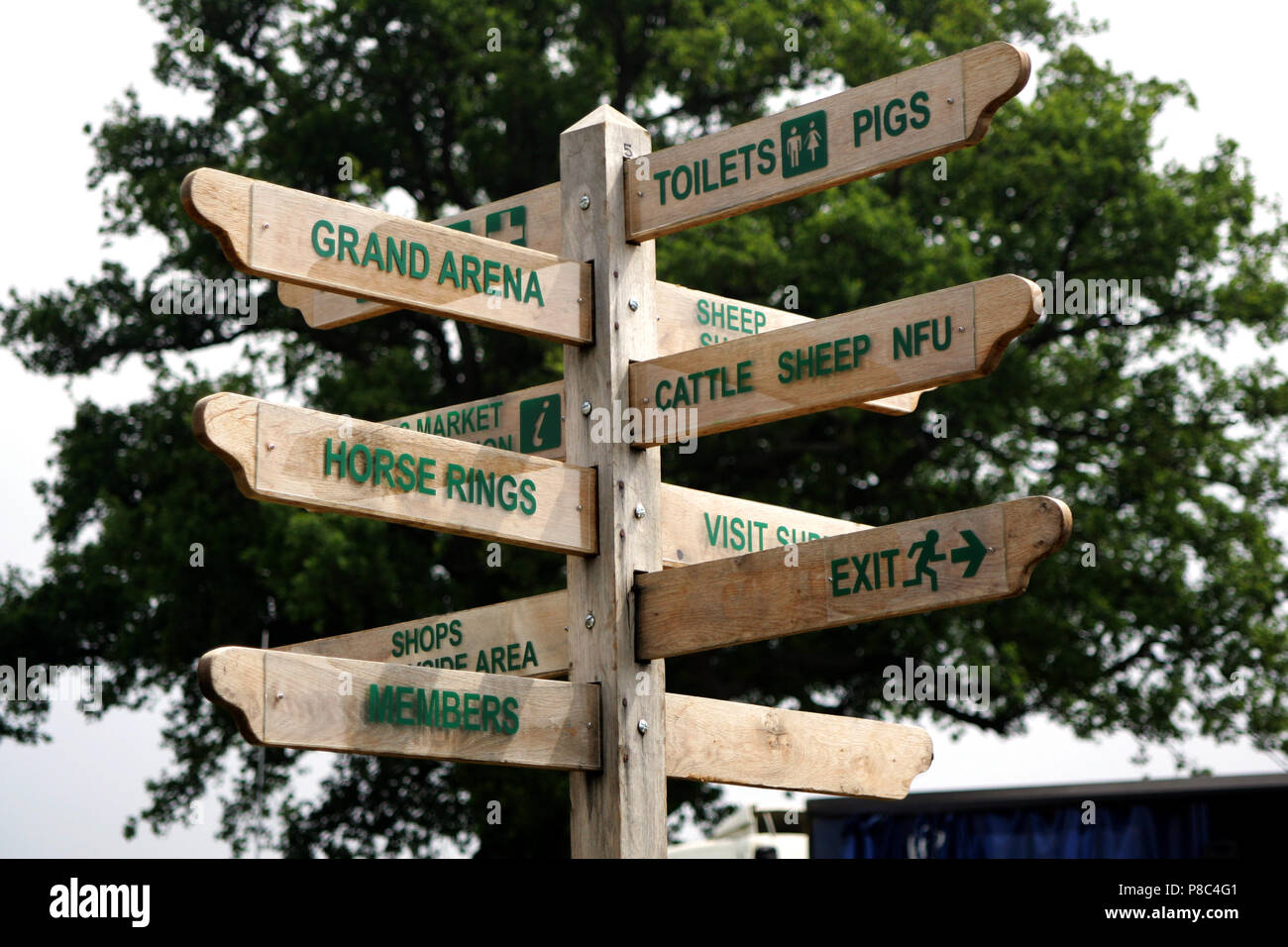 Wooden sign in a showground with twelve arms pointing the way to ...
