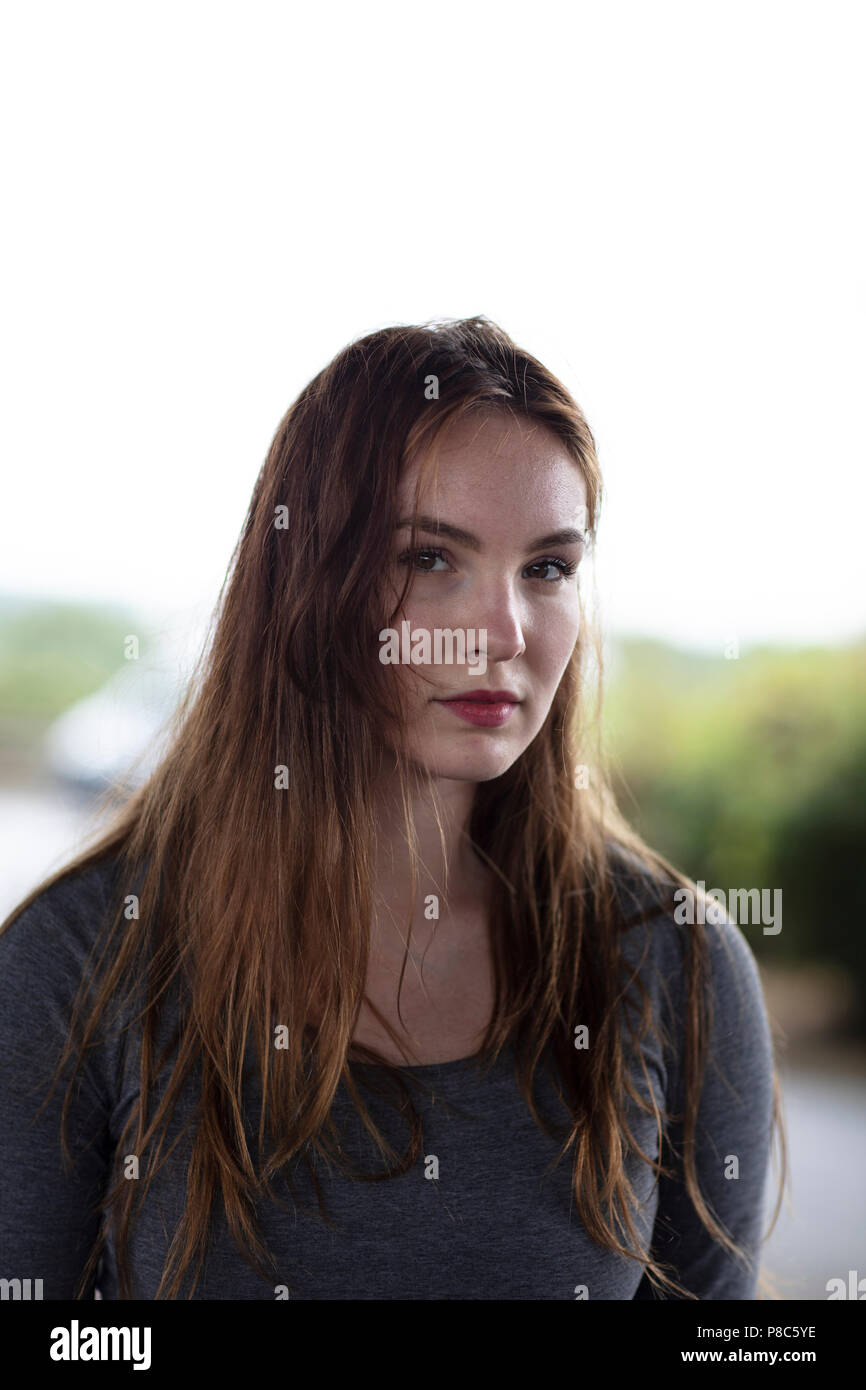 Portrait of a young woman standing outdoors. Medium close up. Selective ...