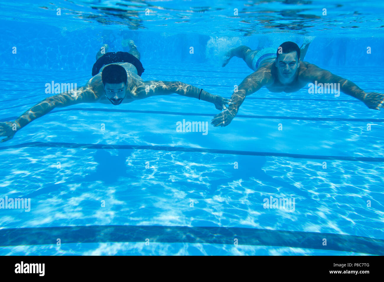 Underwater enjoyment. Two friends having fun underwater in swimming ...