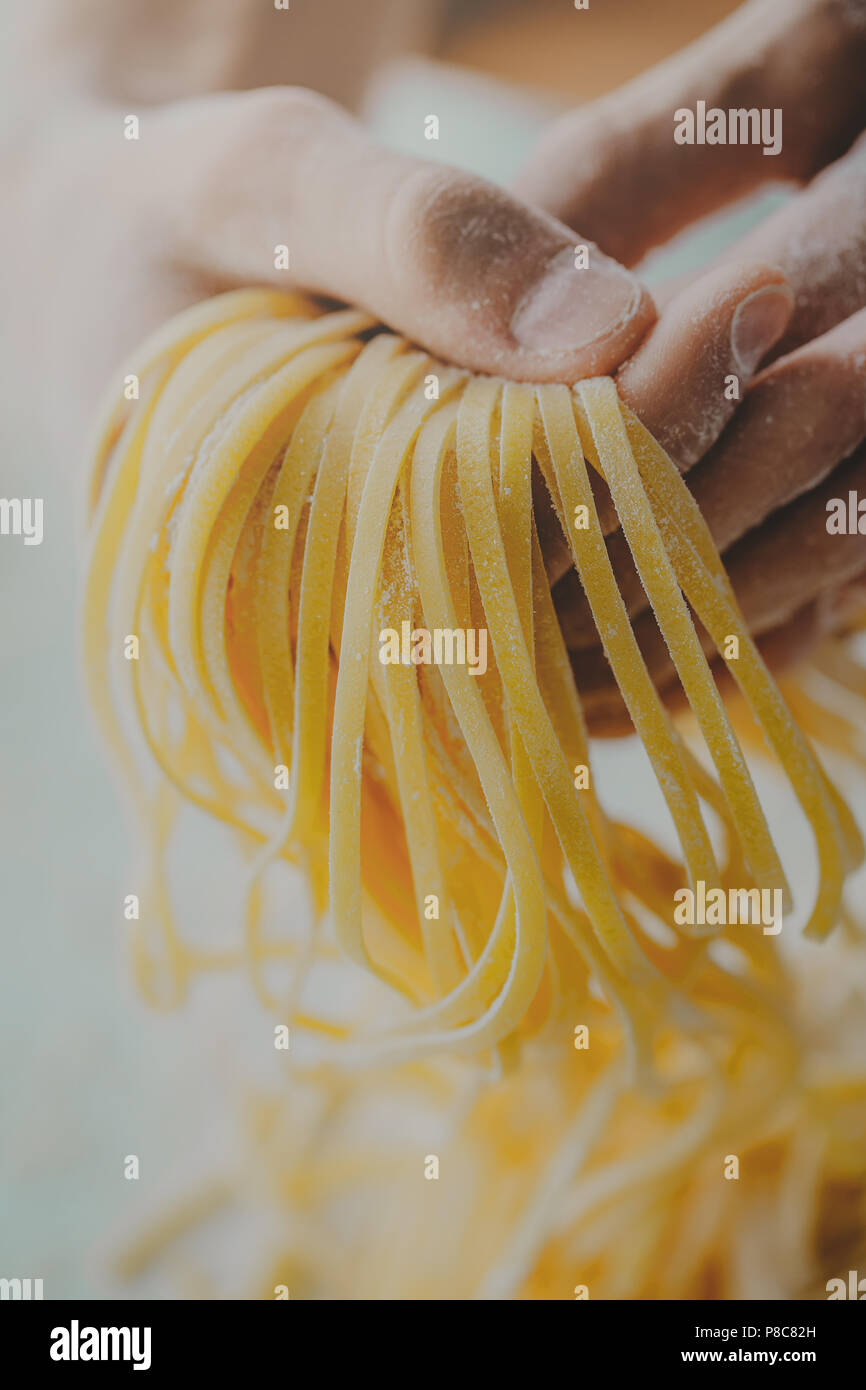 Closeup of process of cooking homemade pasta. Chef make fresh italian ...