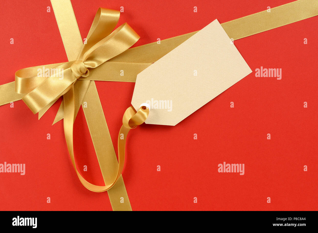 Red gift background, gold ribbon bow, blank gift tag or label, copy ...
