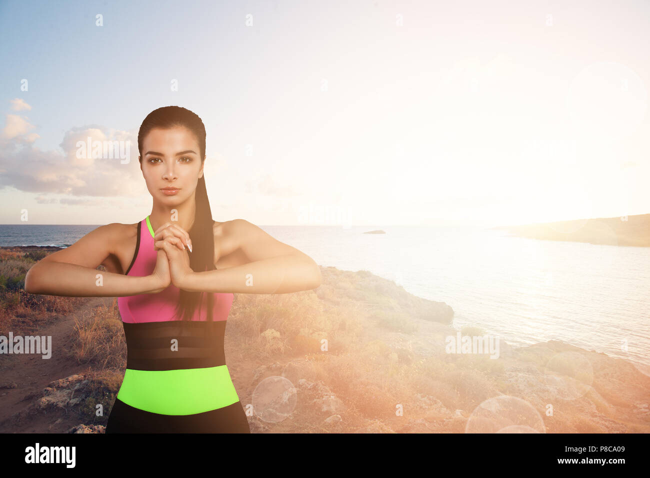 Young woman exercise in a beautiful nature. Girl hands up and standing ...