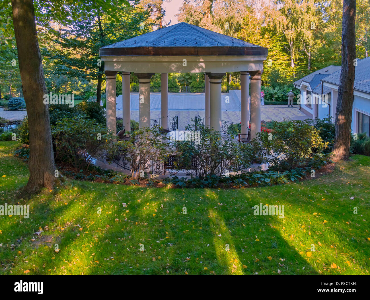 A large arbor for rest with columns supporting the roof with benches ...