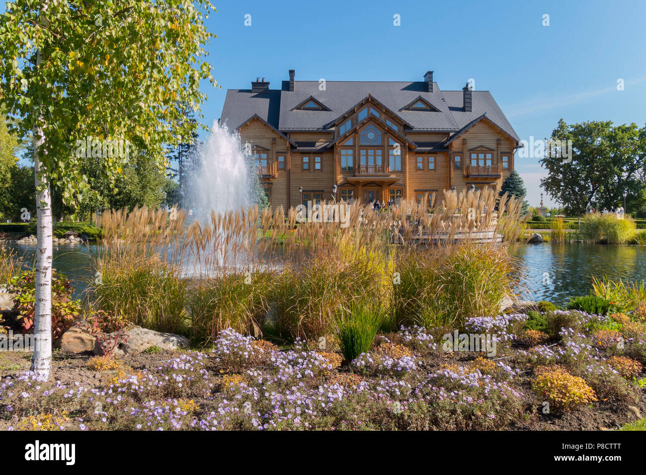 high fountain on the lake in front of a wooden house with balconies ...