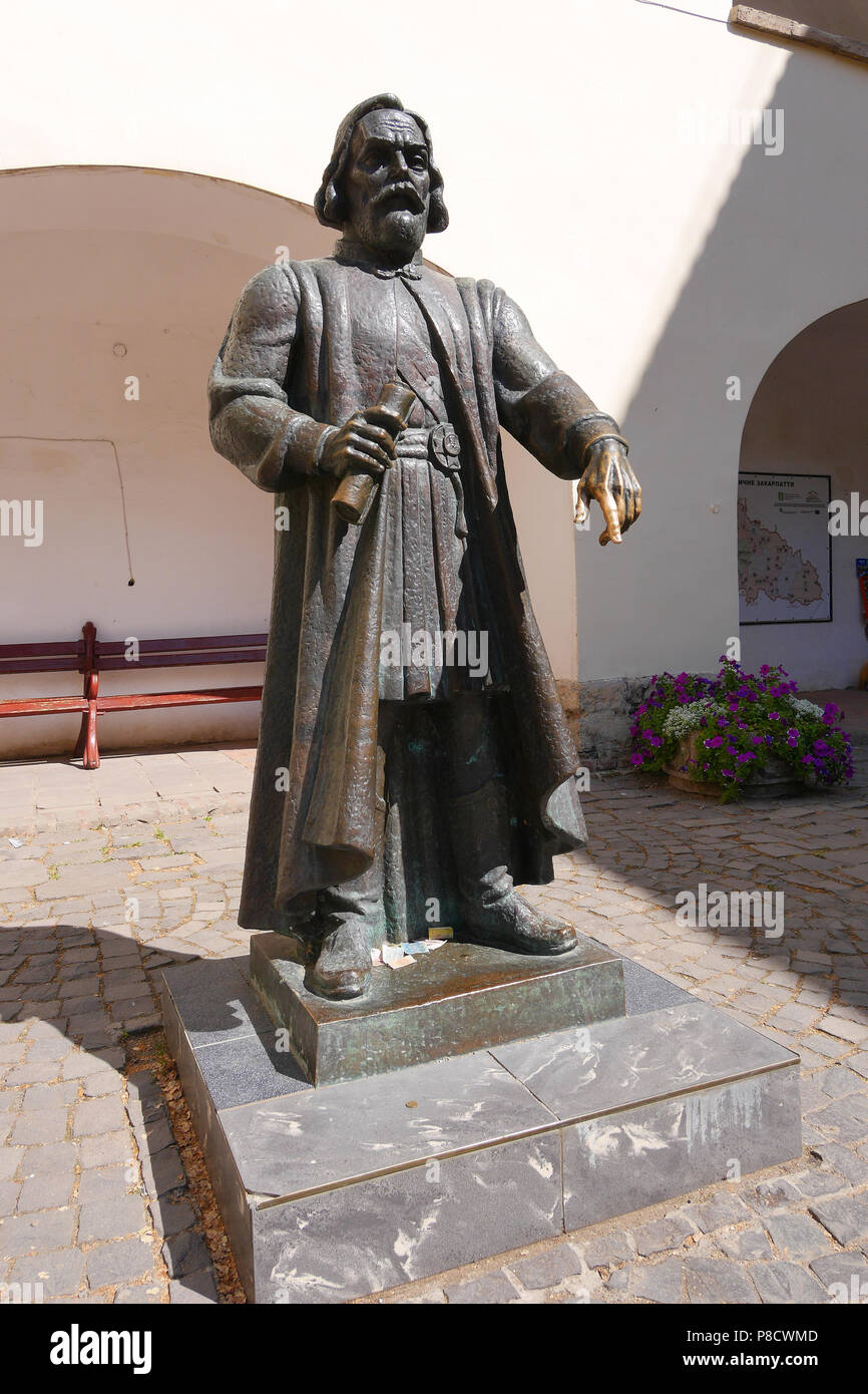 Bronze monument on the background of the arches of the ancient castle ...