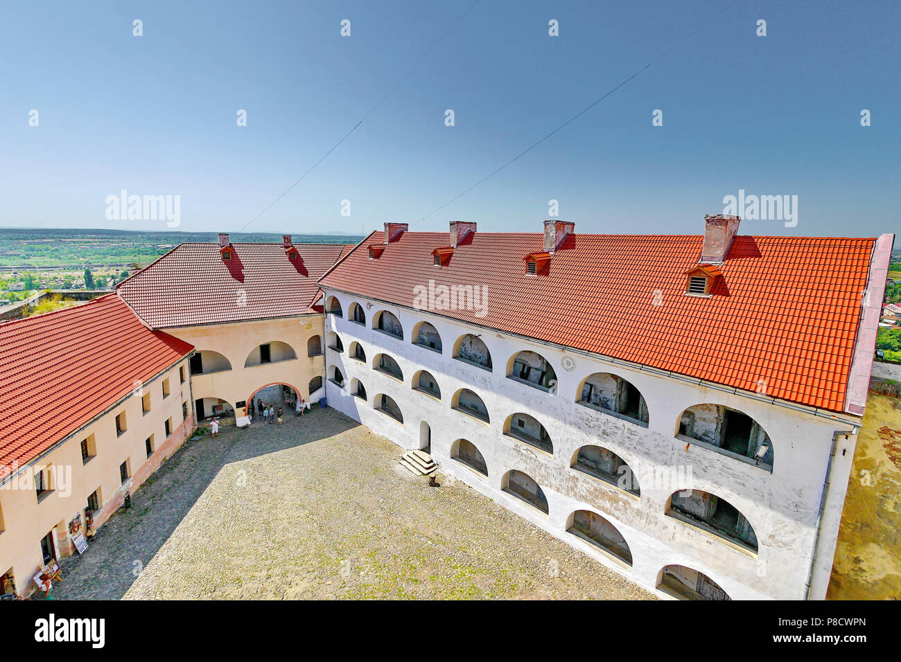 The courtyard is an ancient building with tourists inside. With an ...